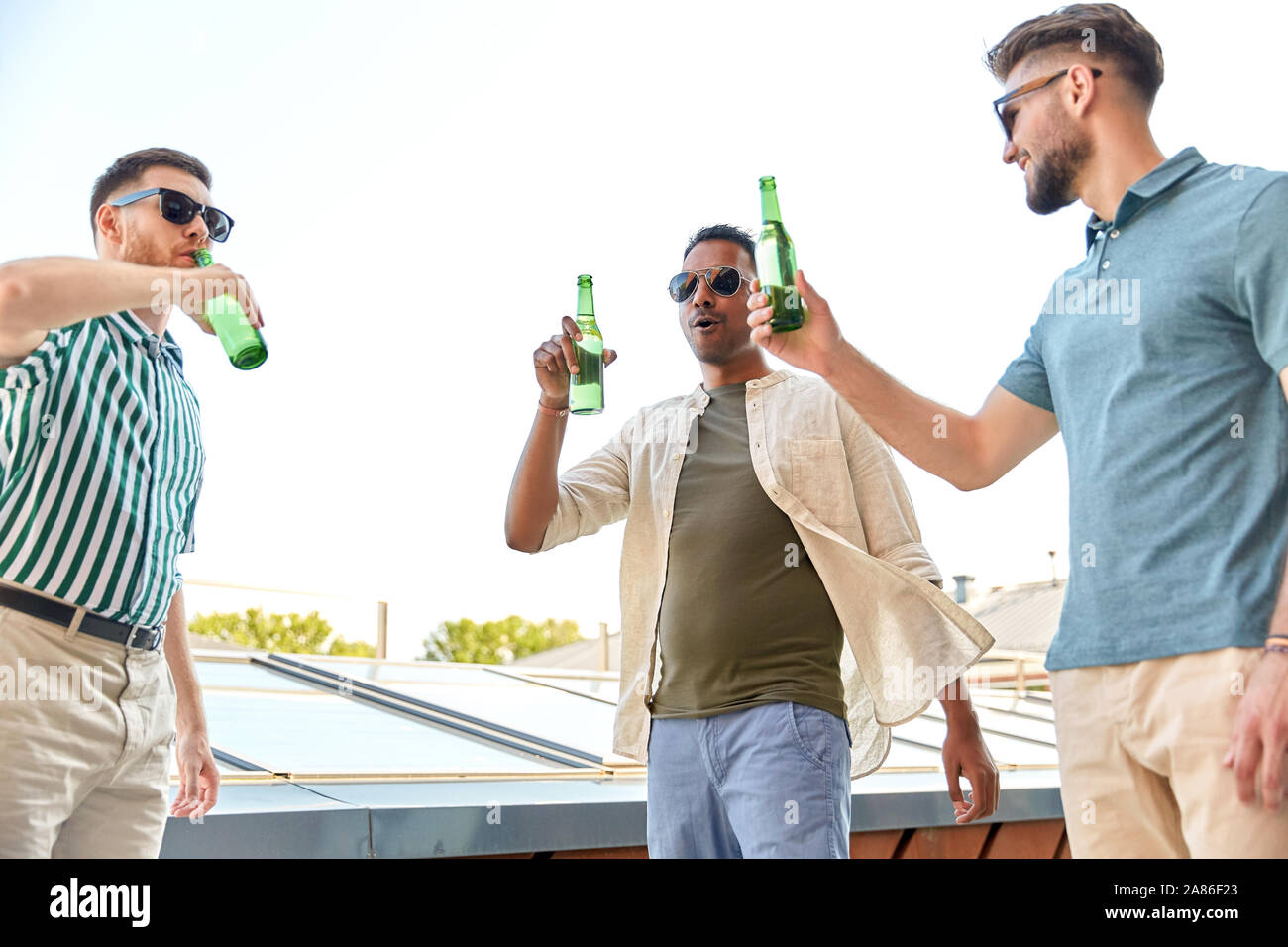 happy male friends drinking beer at rooftop party Stock Photo - Alamy