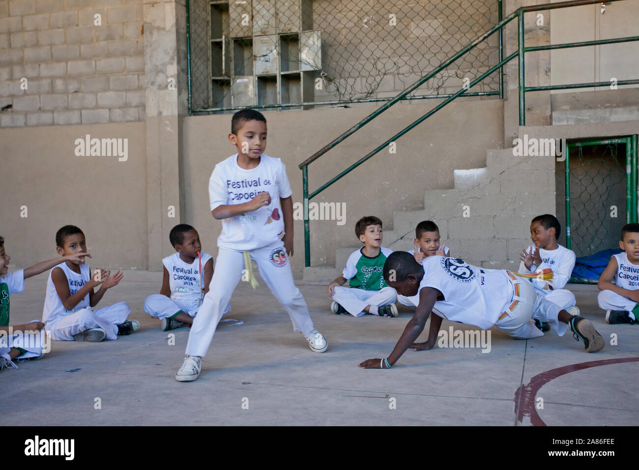 Kids at a Brazilian capoeira class with a teacher playing a berimbau ...