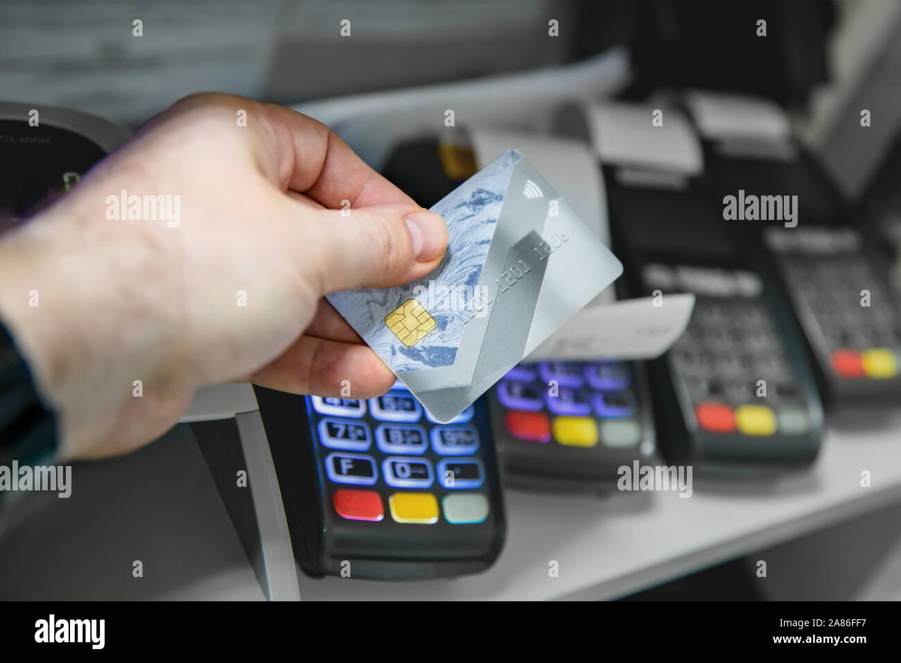 plastic card in hand and credit card machines with shallow depth of ...