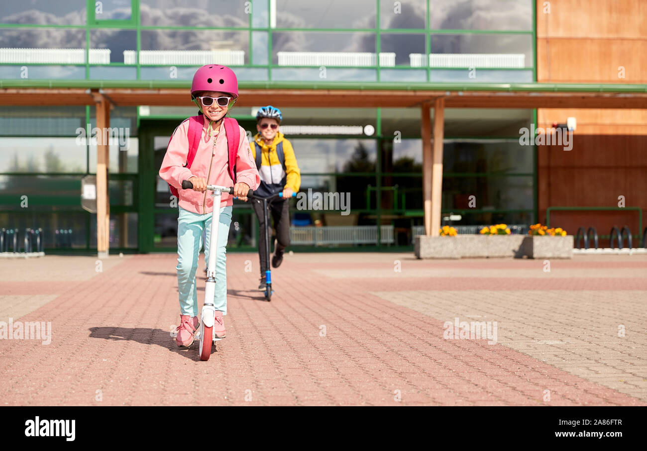 happy school children riding scooters outdoors Stock Photo - Alamy