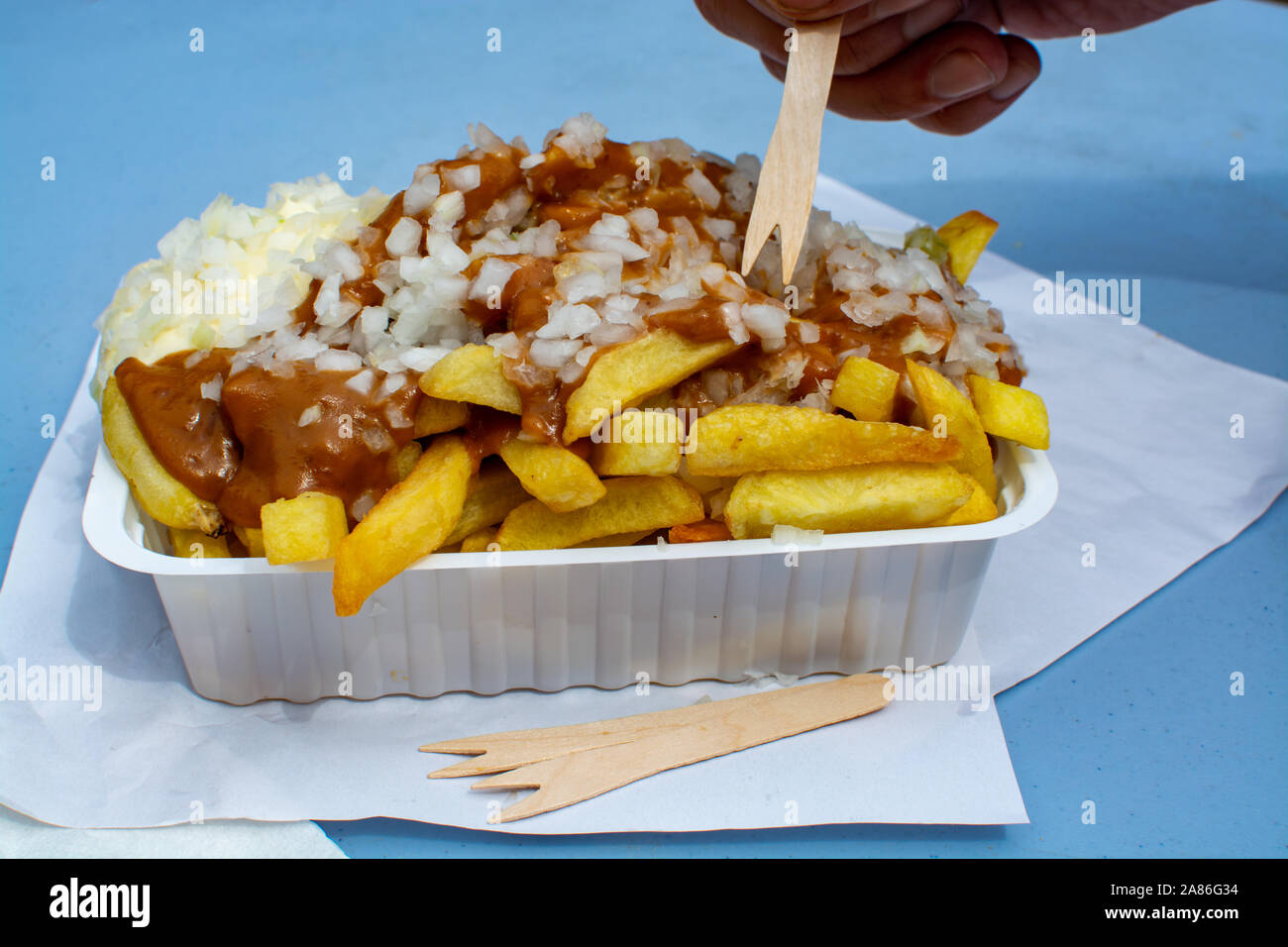 Traditional Dutch fast food dish, fried potatoes with sate sauce, onion ...
