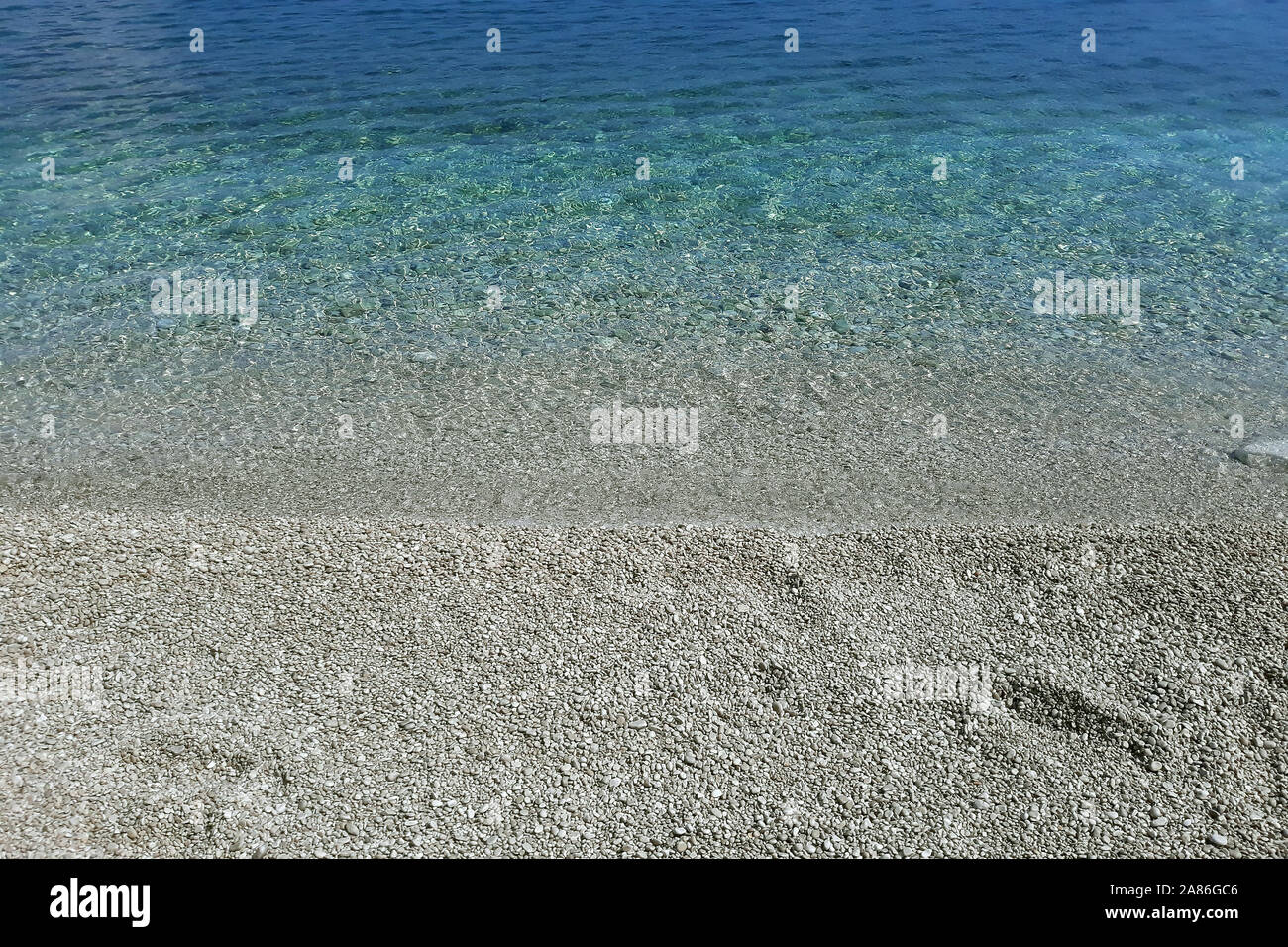 Border between water and land on a pebble beach of the Adriatic in ...