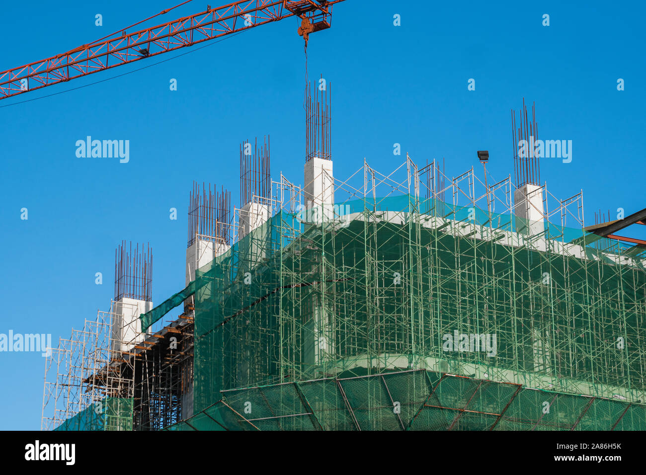 Crane and building construction site against blue sky. Metal ...