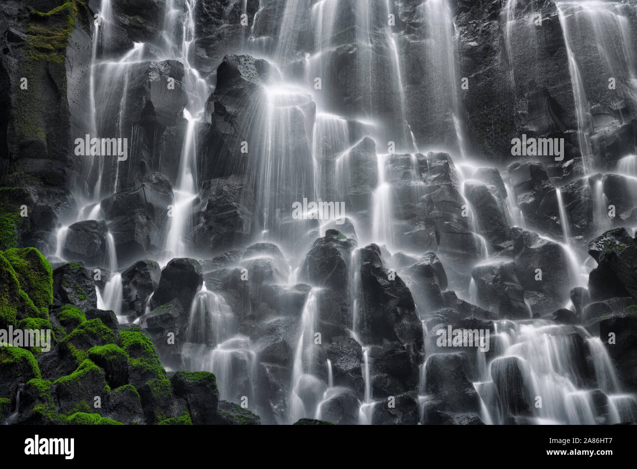 A veil of water pours over Oregon’s Ramona Falls and the moss covered ...