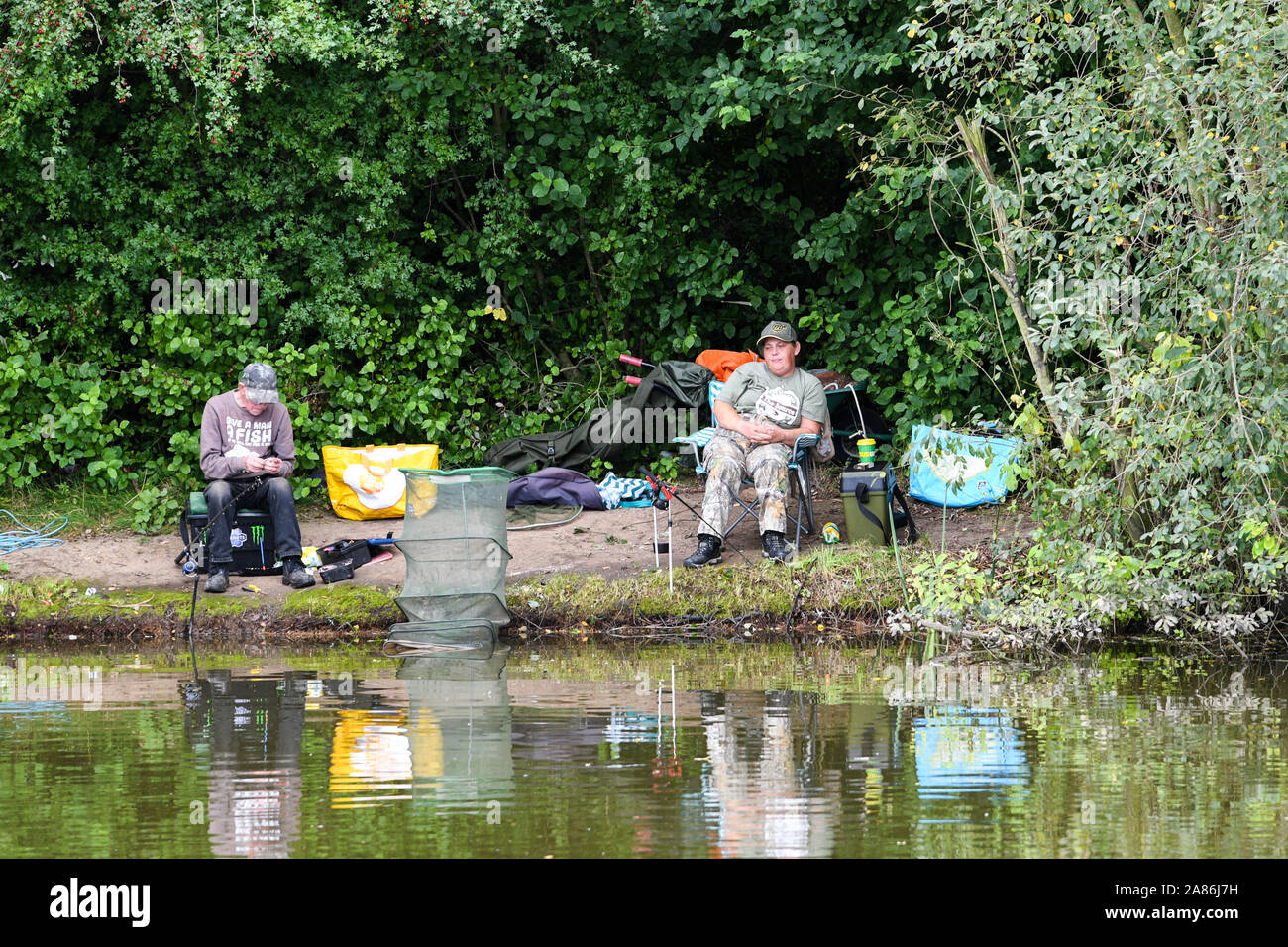 people fishing on a lake Stock Photo - Alamy