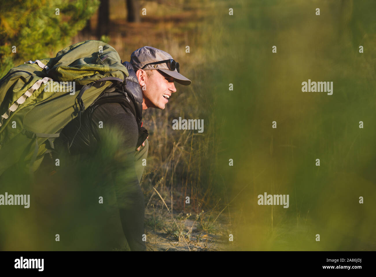 Older man walking in forest with green backpack feeling exhausted Stock ...