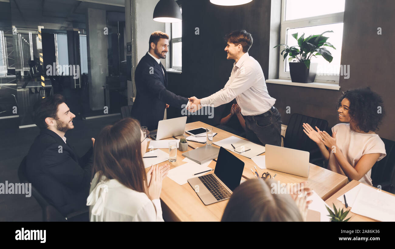 Business partners handshaking at meeting and receiving applause Stock ...