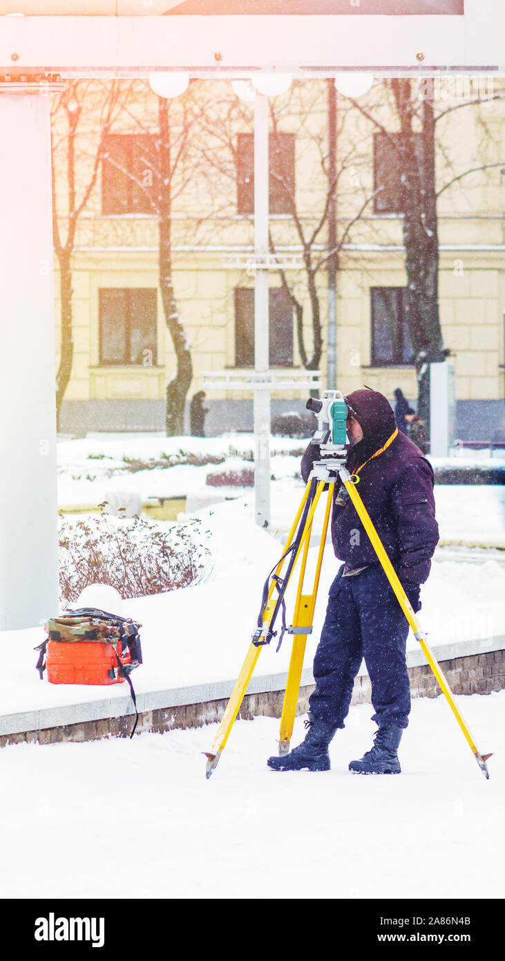 Surveyor engineer uses a total station at a construction site. Geodetic ...