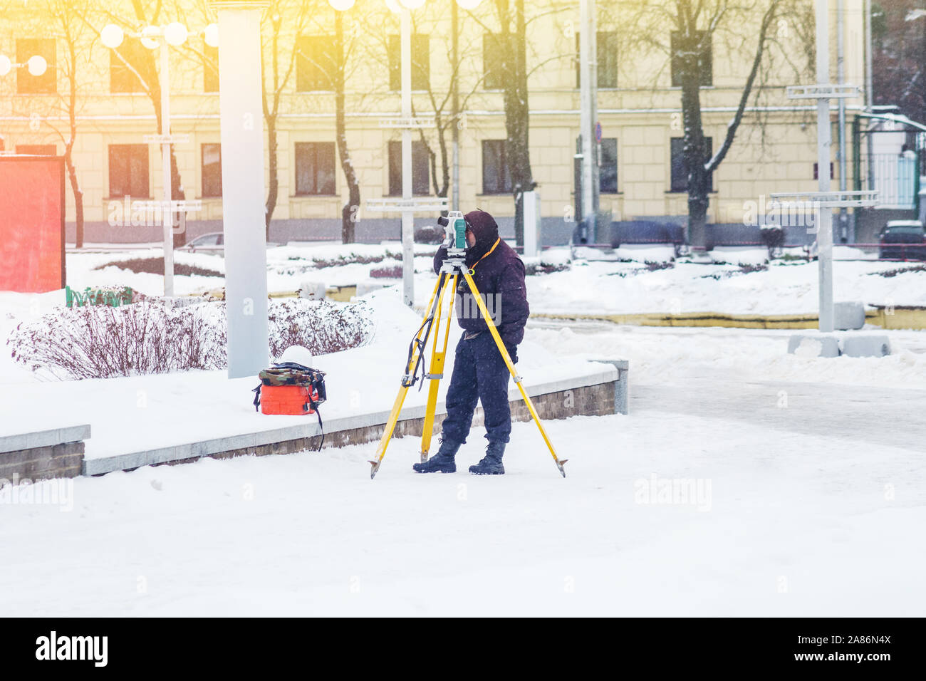 Surveyor engineer uses a total station at a construction site. Geodetic ...