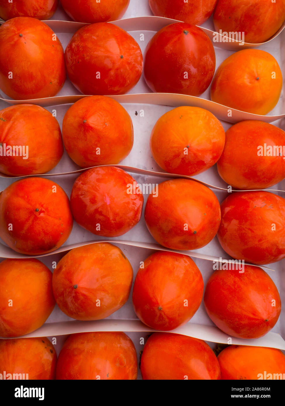 Fresh ripe persimmons in market. Organic persimmon fruit in pile at ...