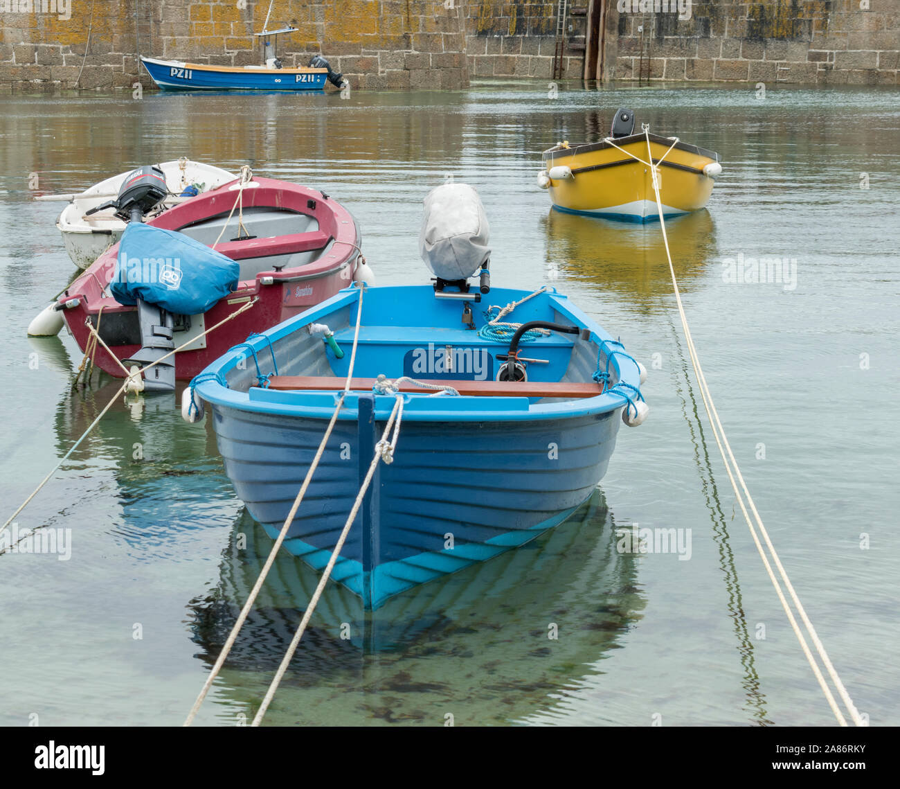 Boats in the enclosed safety of the harbour at Mousehole near Penzance ...