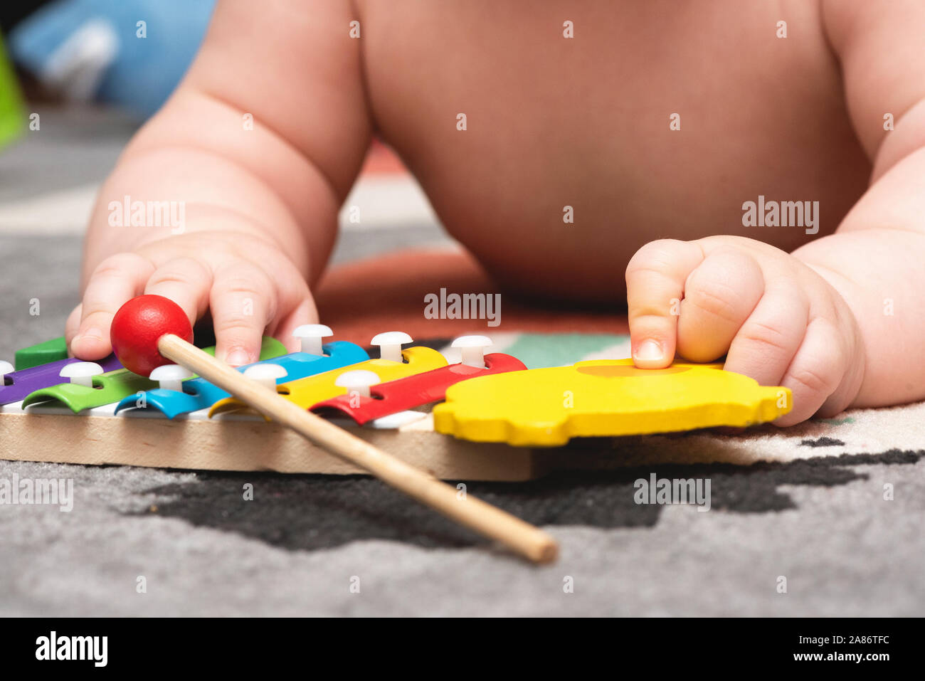 Little boy is playing with music instrument for kids on the floor Stock ...