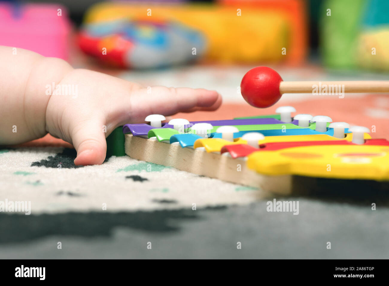 Little boy is playing with music instrument for kids on the floor Stock ...