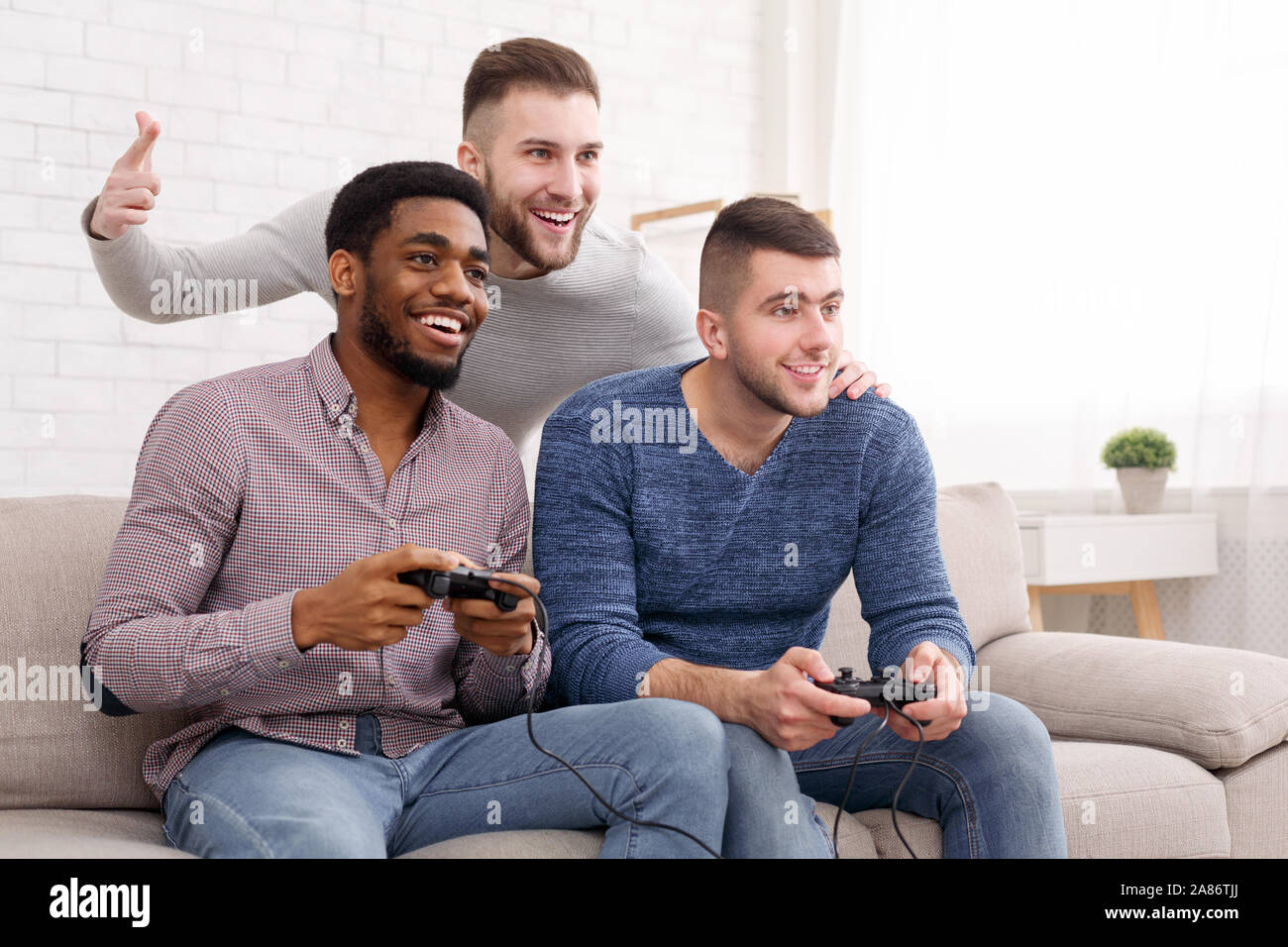 Online competition. Friends competing in video games Stock Photo - Alamy