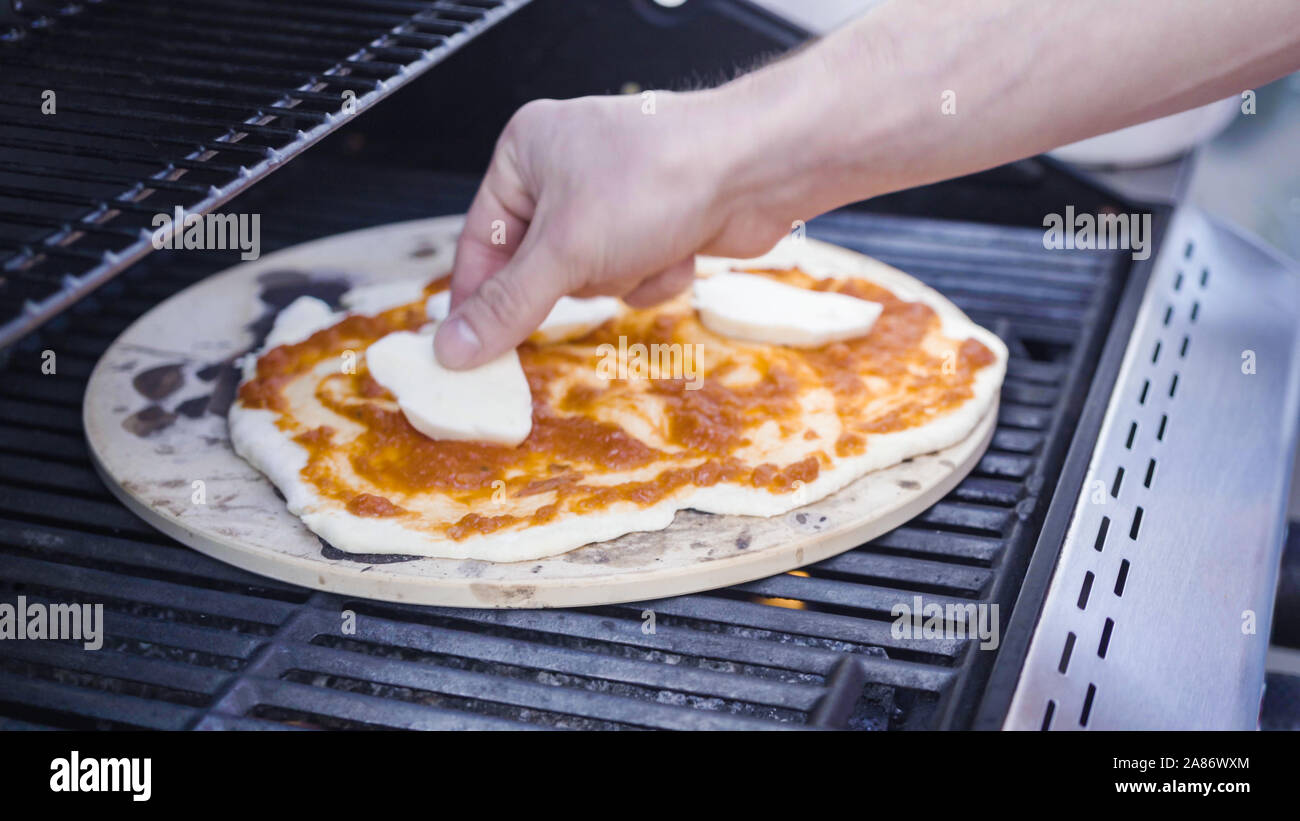 Cooking pizza on outdoor gas grill Stock Photo - Alamy