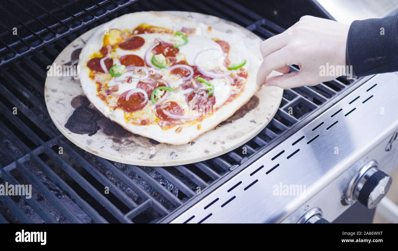 Cooking pizza on outdoor gas grill Stock Photo - Alamy