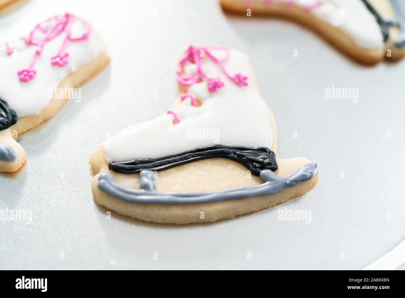 Decorating sugar cookies shaped as figure skates with royal icing Stock ...