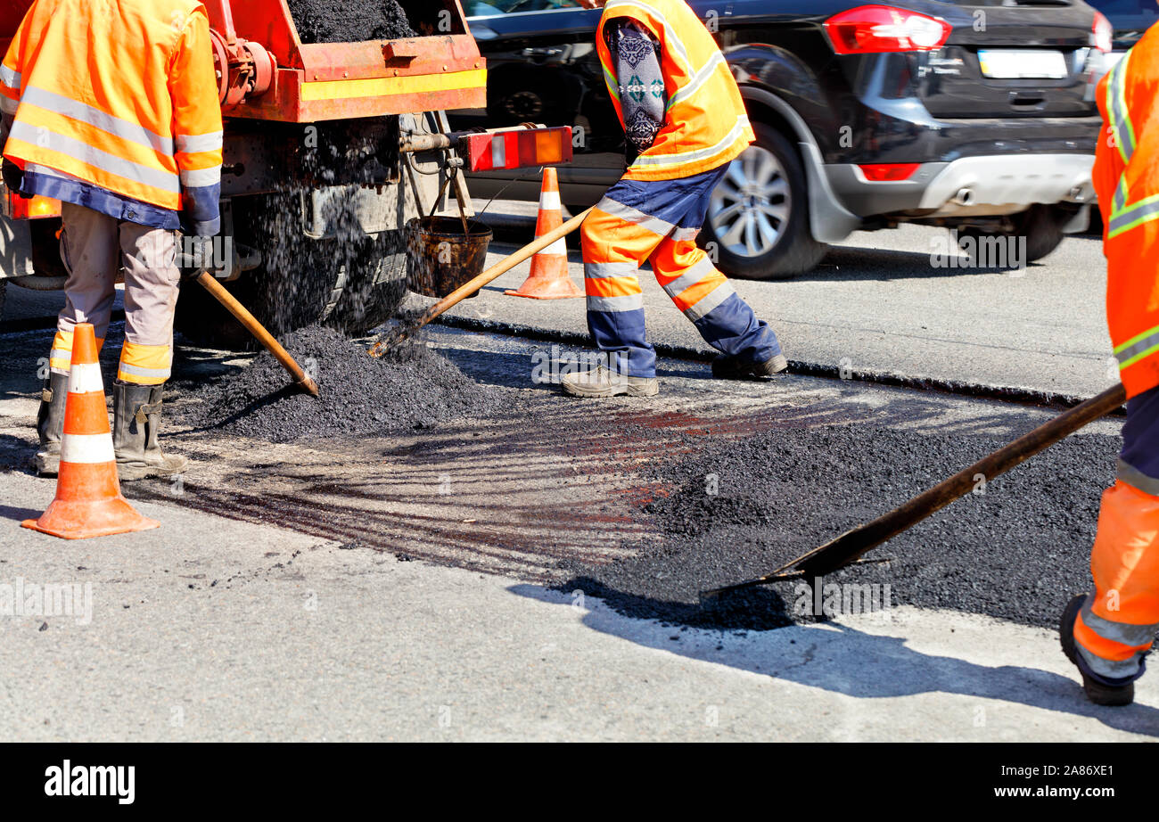 The group of road workers updates part of the road with fresh asphalt ...