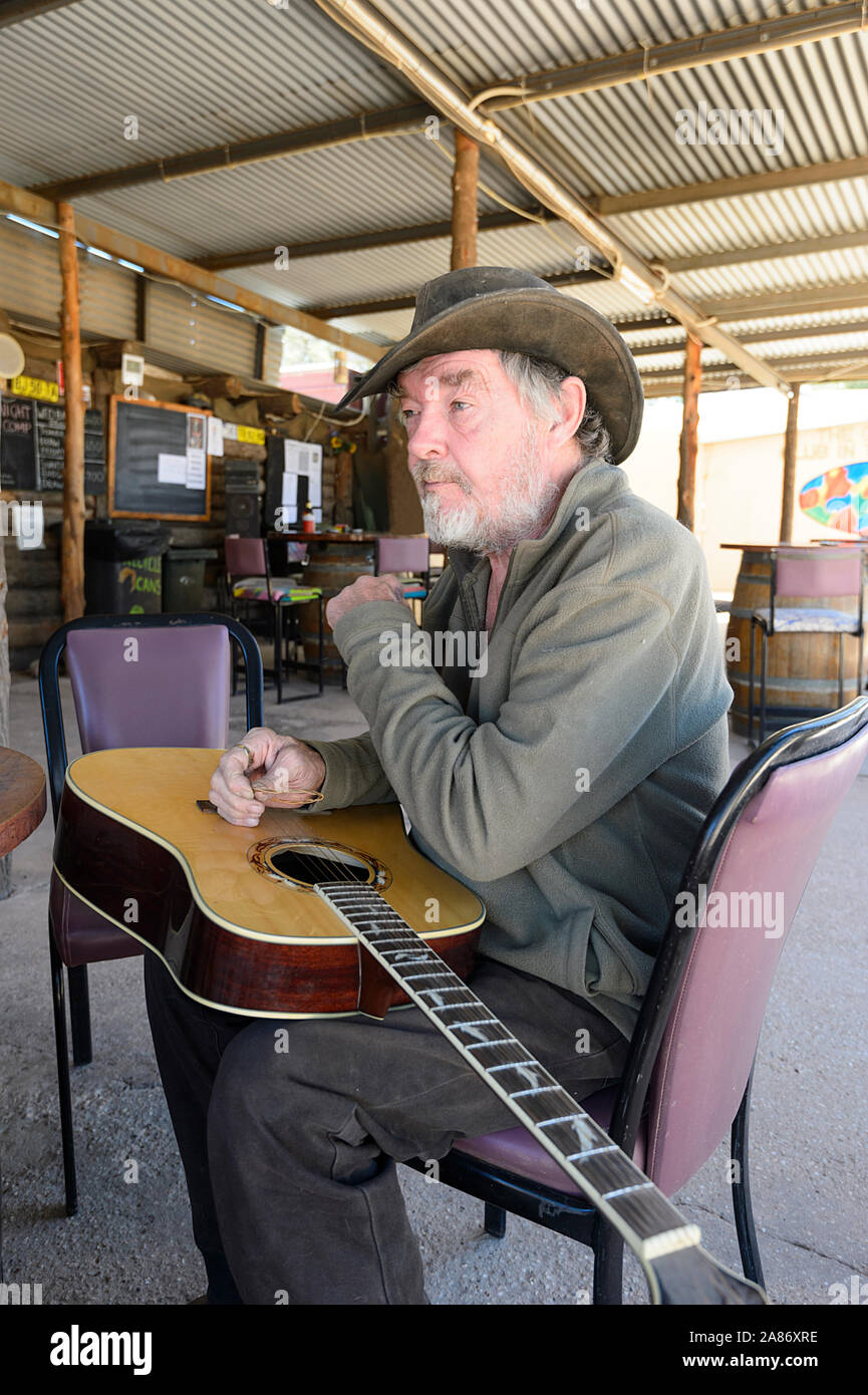 Older man with a guitar sitting outside the iconic Club in the Scrub ...