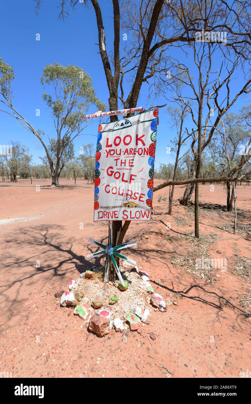 Warning sign of a golf course in the red dust of the Outback, the ...