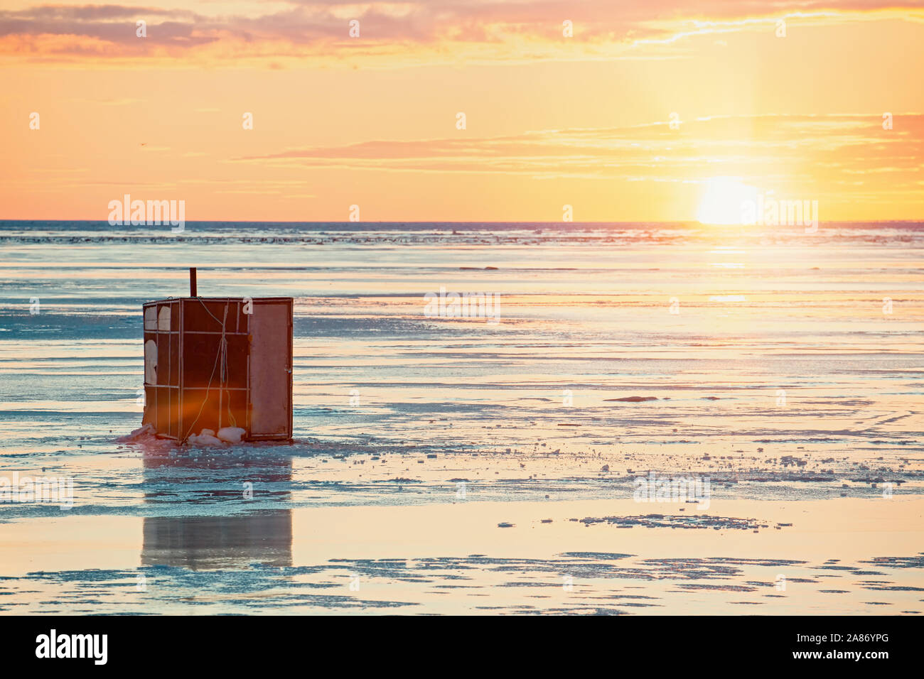 Ice fishing on a frozen harbor along the coast of rural Prince Edward ...