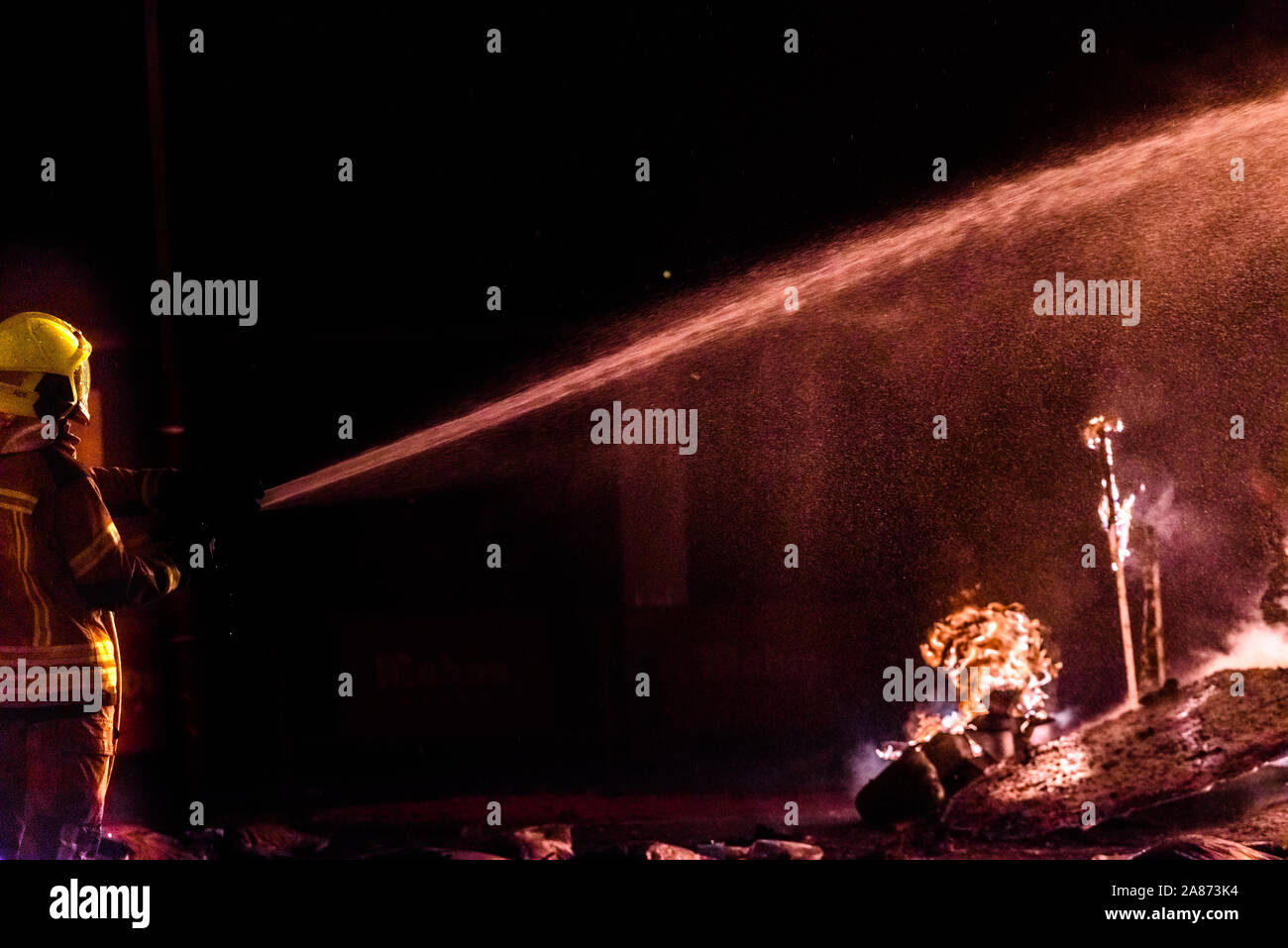 Firefighter with his protective suit working controlling the burning of ...