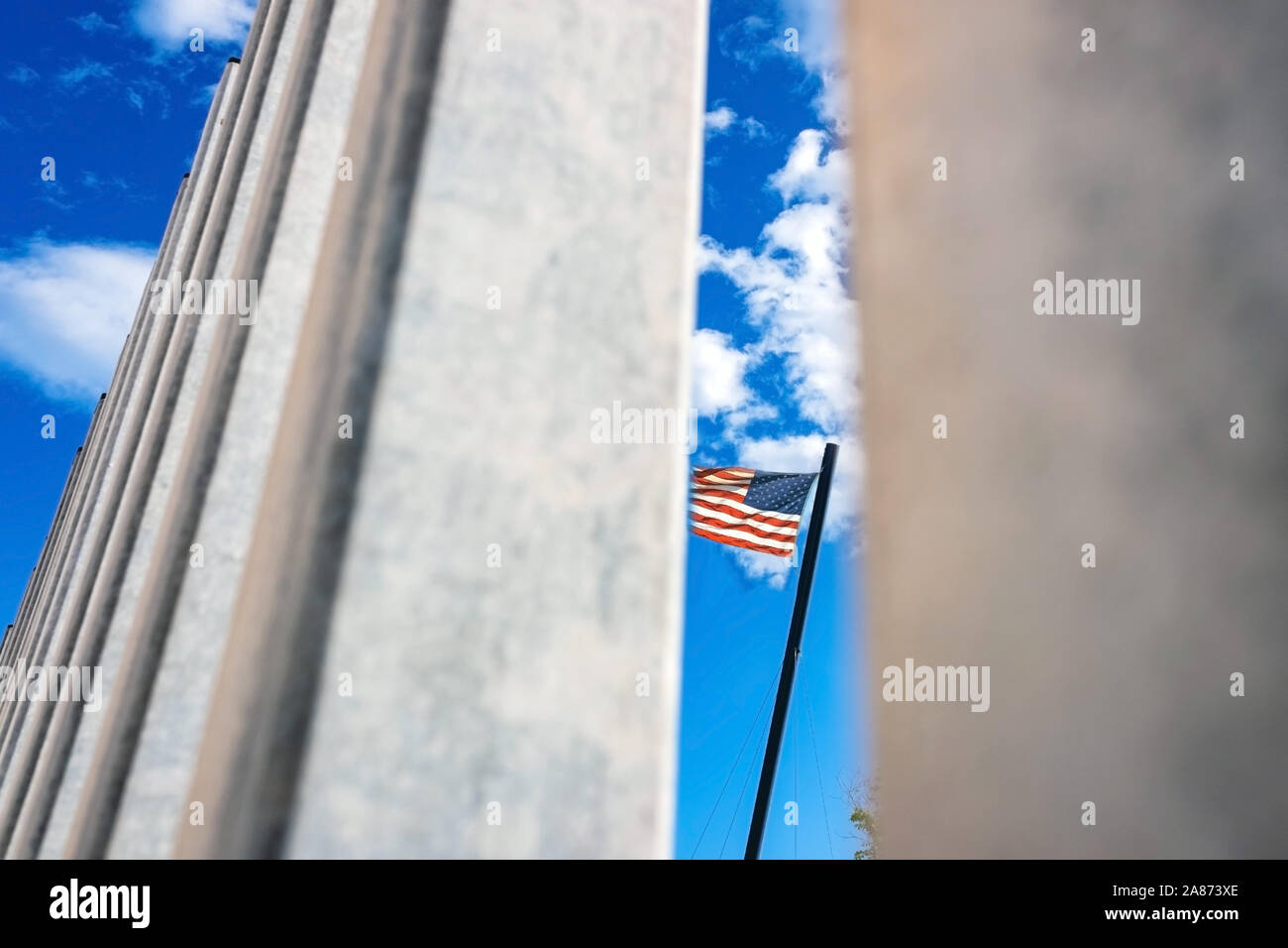 American flag waving across the border seen behind the bars of a ...