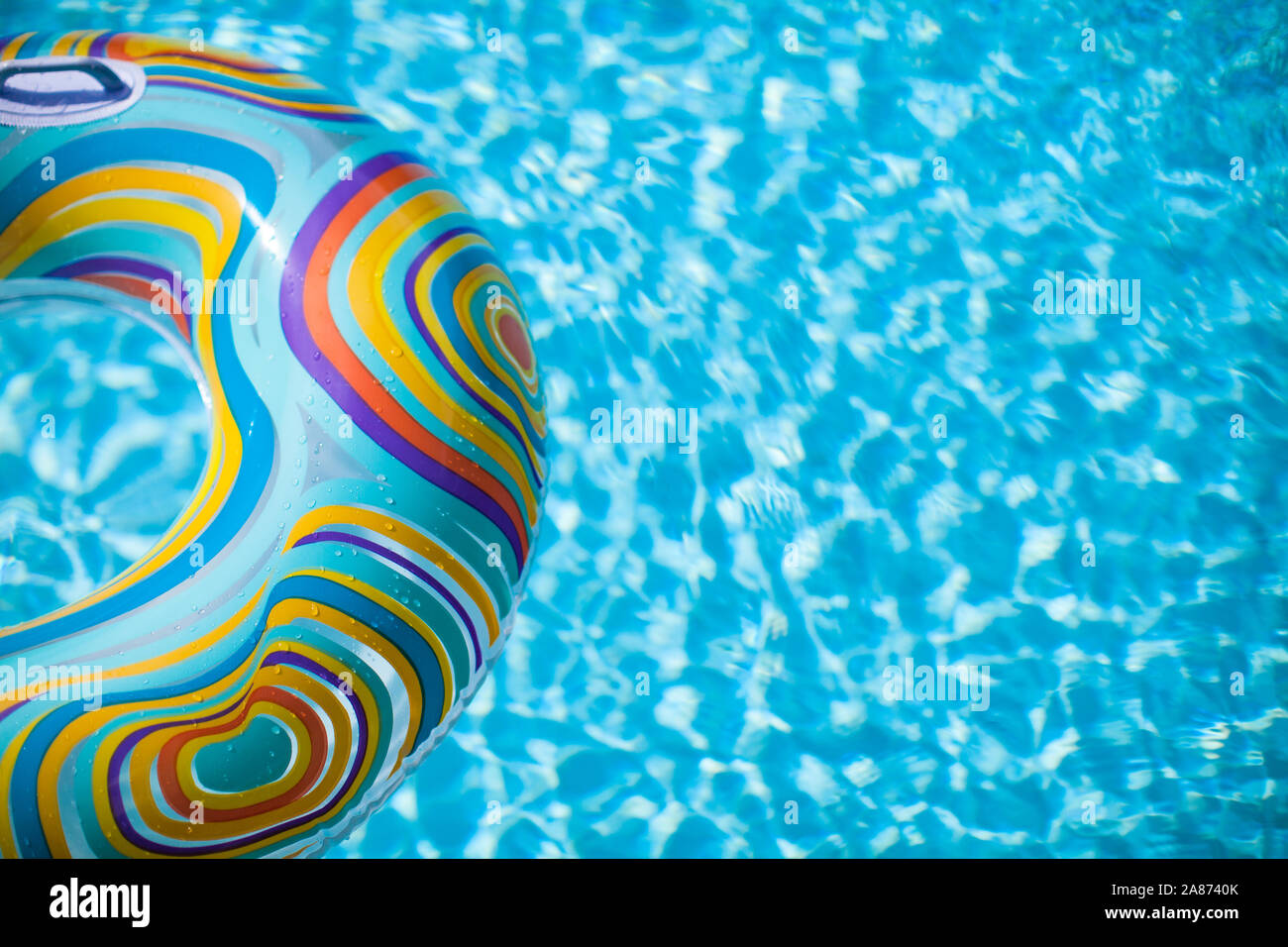Colorful pool float in blue swimming pool Stock Photo - Alamy