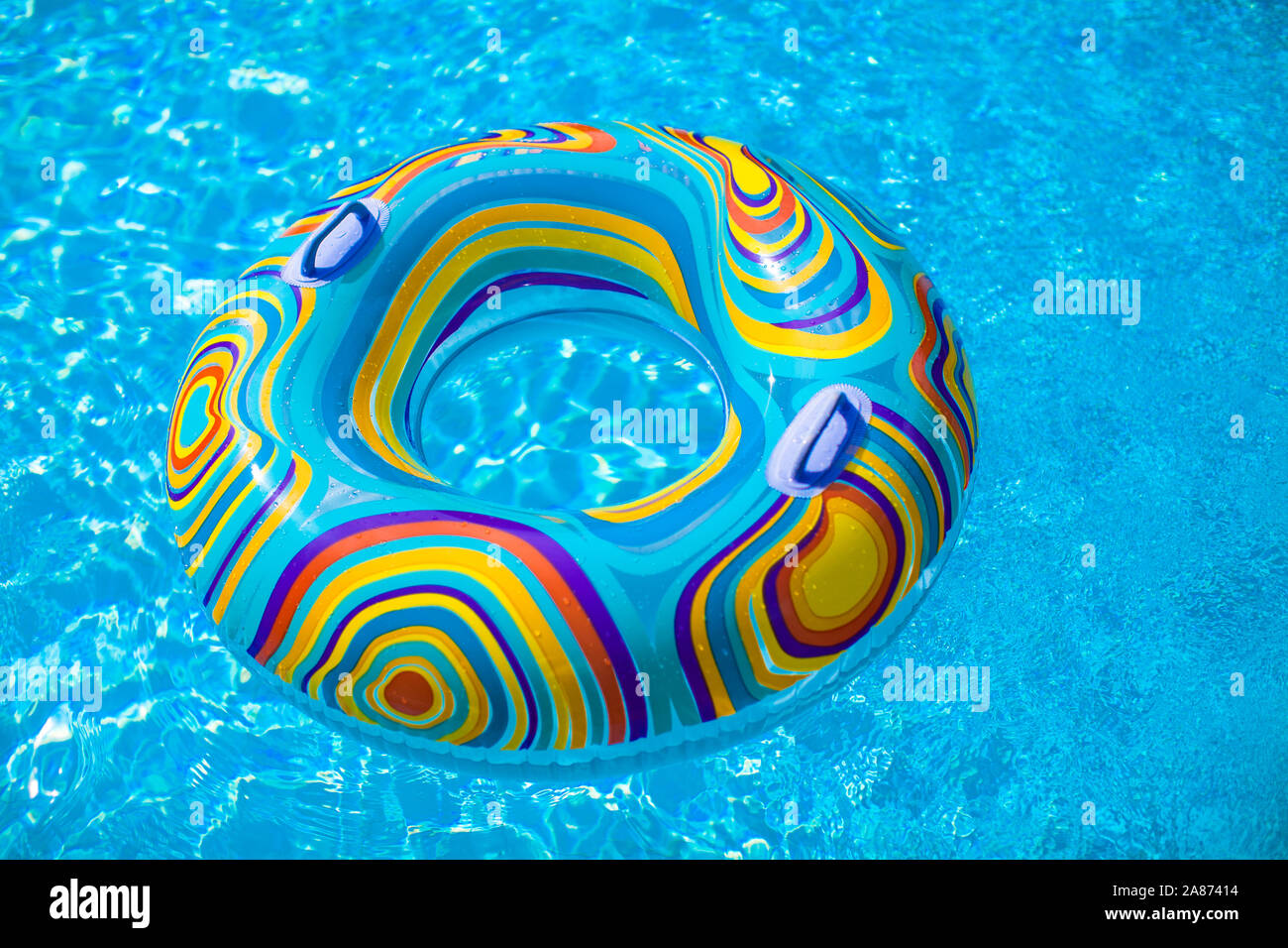 Colorful pool float in blue swimming pool Stock Photo - Alamy