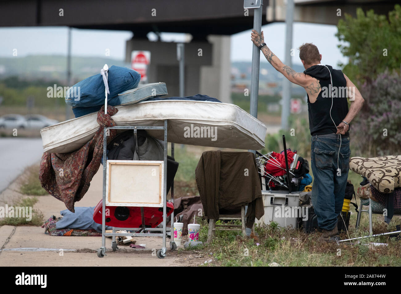 Ray Harvey piles his belongings near a temporary homeless camp under a ...