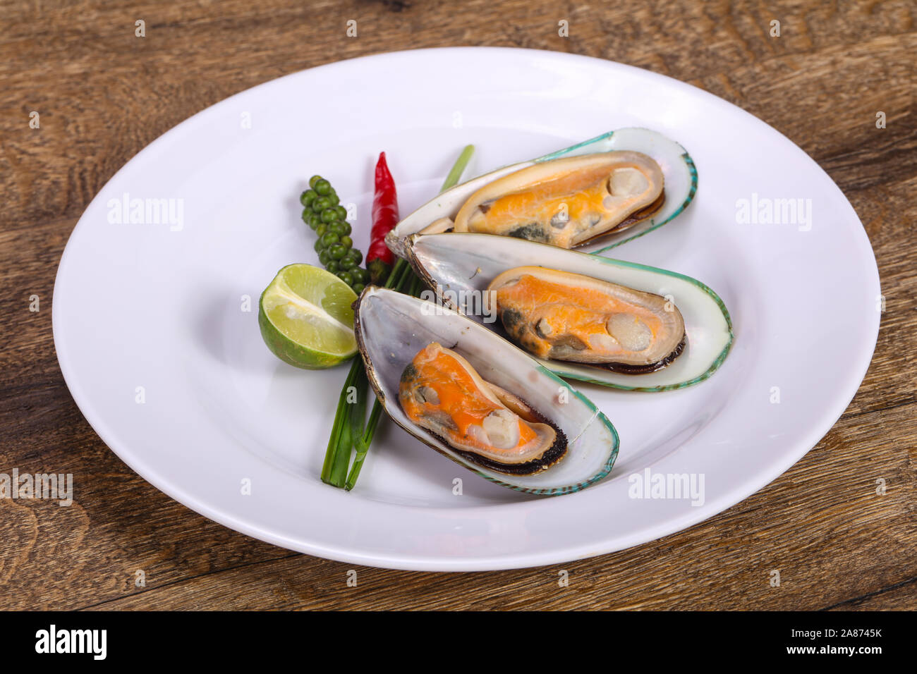 Half mussels with lime and green pepper Stock Photo - Alamy