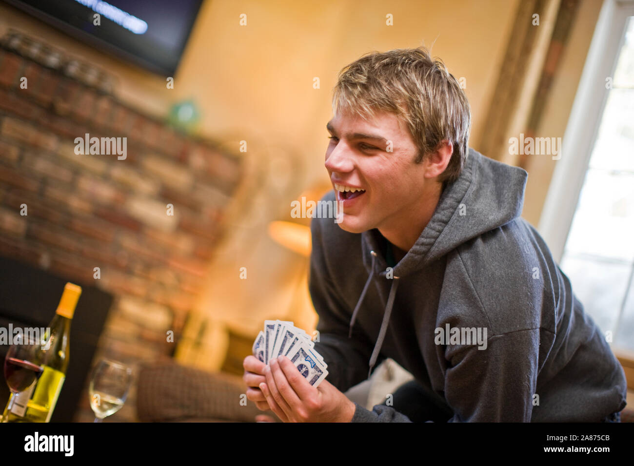 Young man playing cards Stock Photo - Alamy