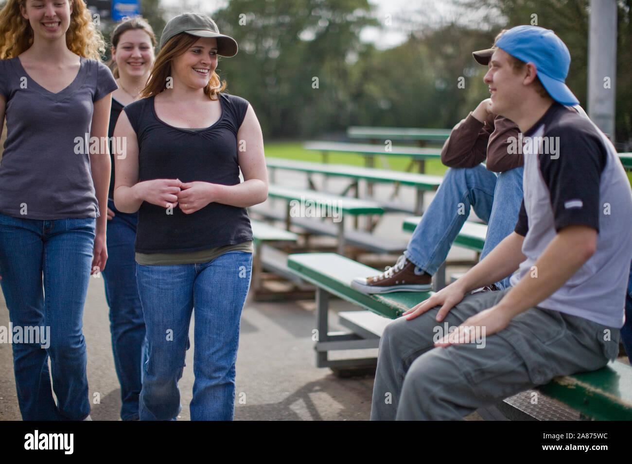 Women walking past men at sport field Stock Photo - Alamy