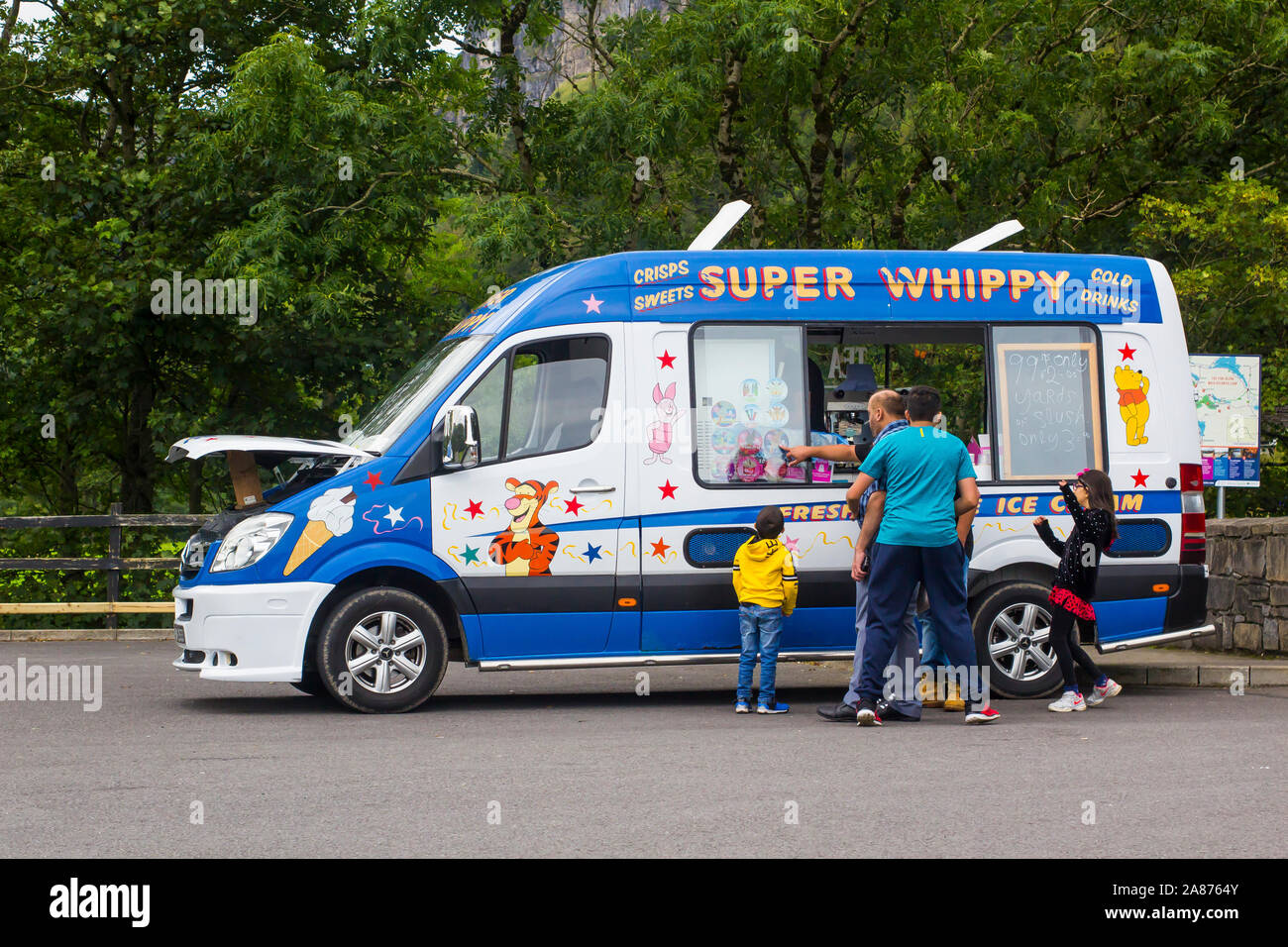 23 August 2019 Customers at a small ice cream vending van in the car ...