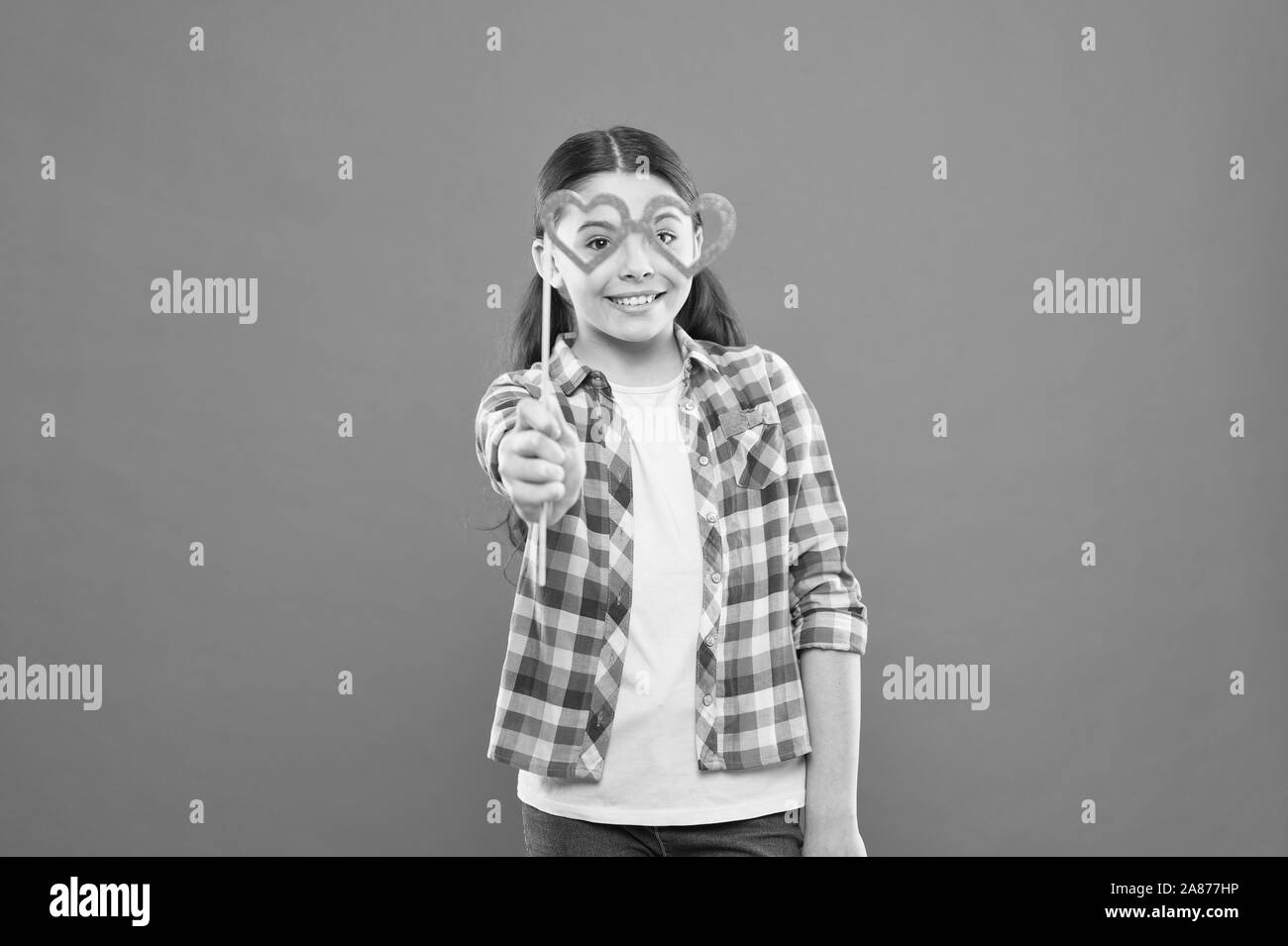 Fun Valentines props. Cute kid smiling with fancy party props on orange ...
