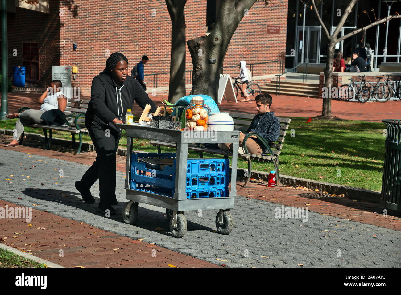 Campus worker carries food cart for student cafe University of ...