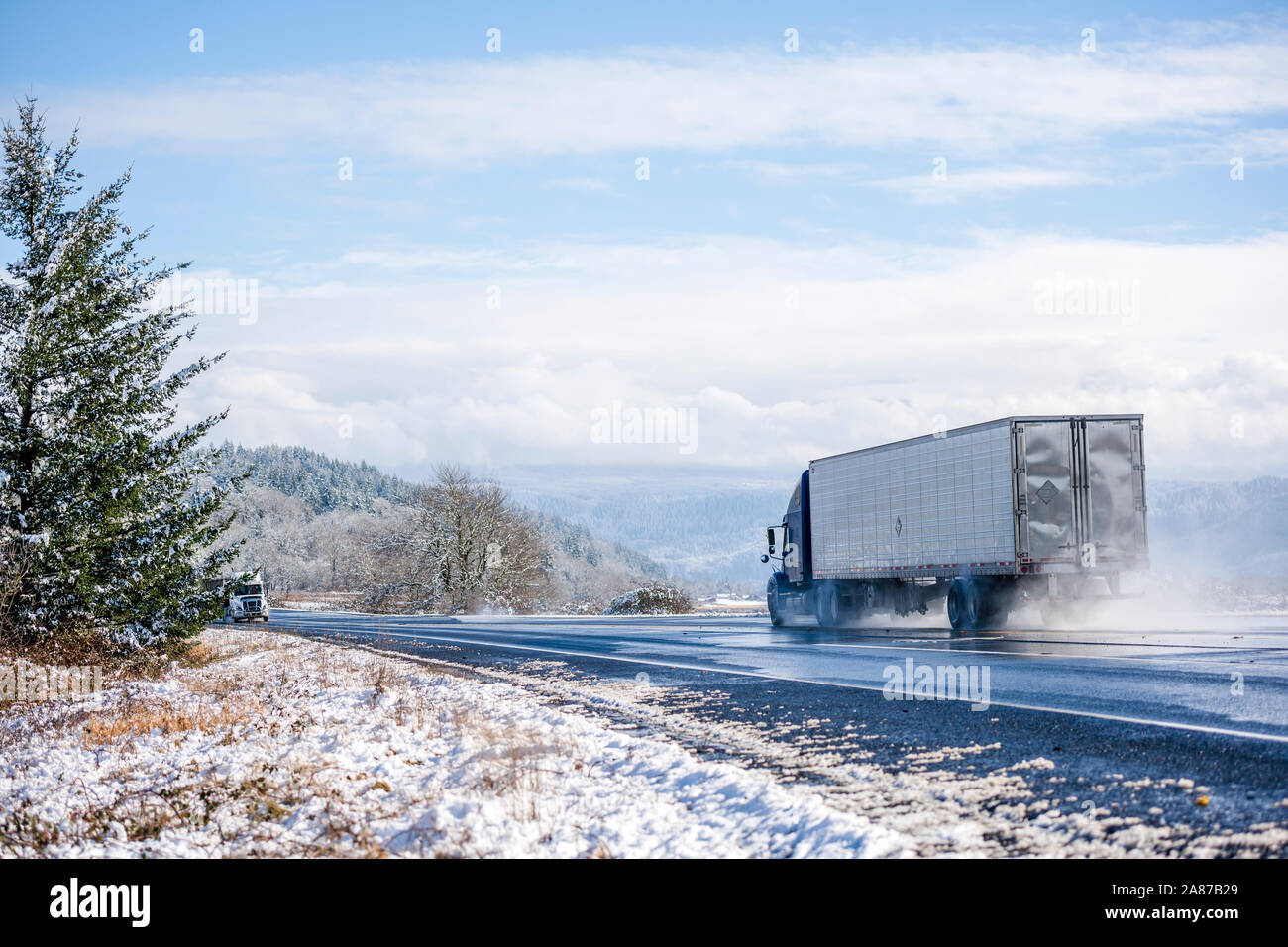 Two big rigs semi trucks with different semi trailers go towards each ...