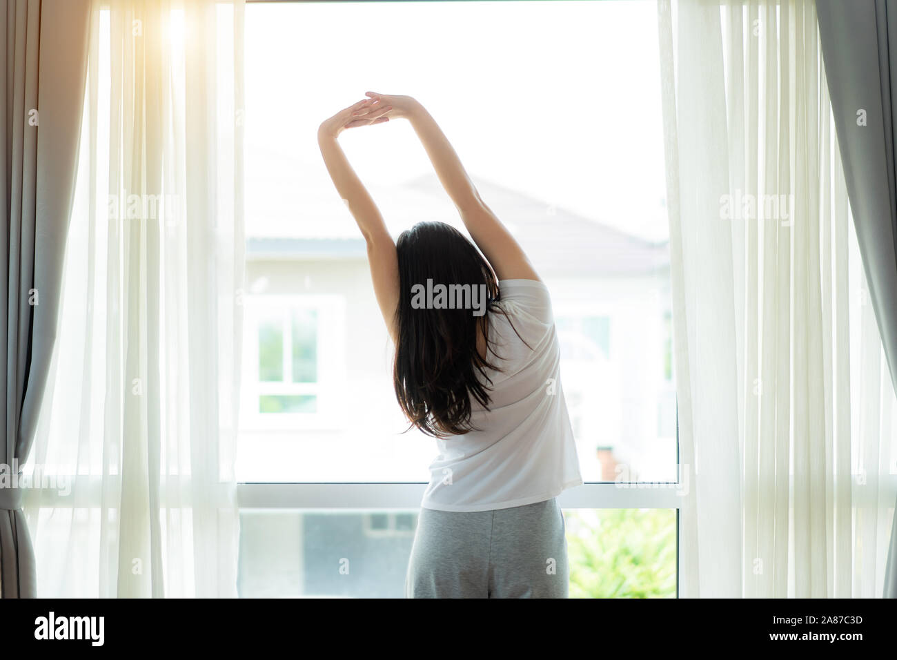 Rear view of woman stretching hi-res stock photography and images - Alamy