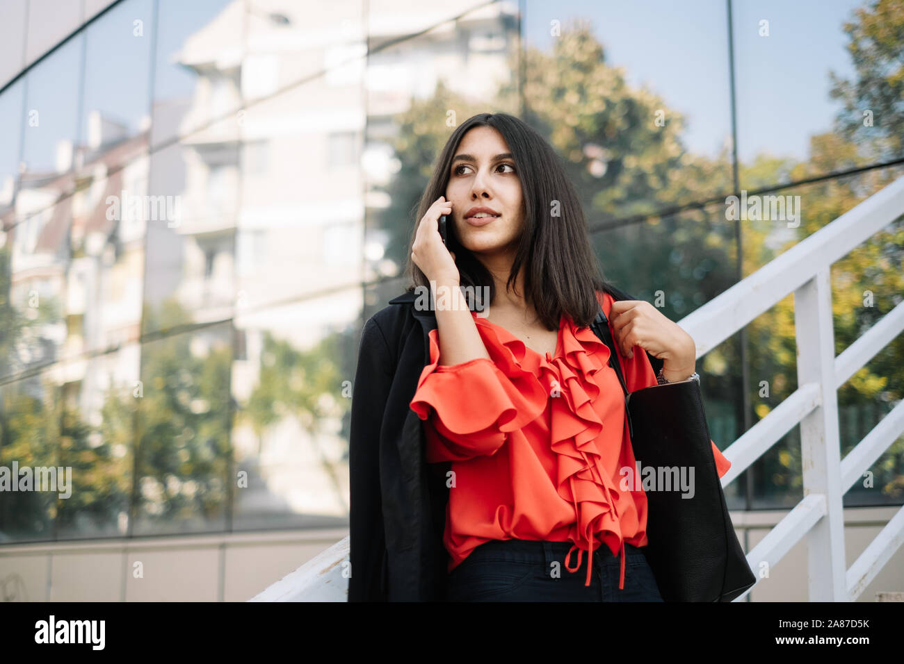 Outdoor female office worker making phone calls Stock Photo - Alamy