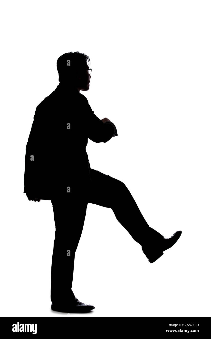 Silhouette of a backlit model posing as a businessman on a white ...