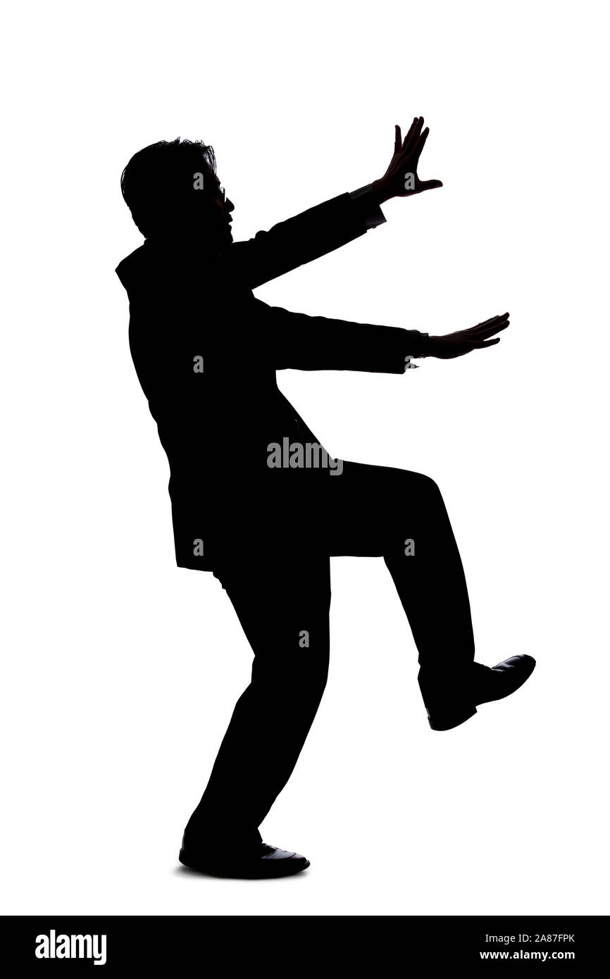 Silhouette of a backlit model posing as a businessman on a white ...