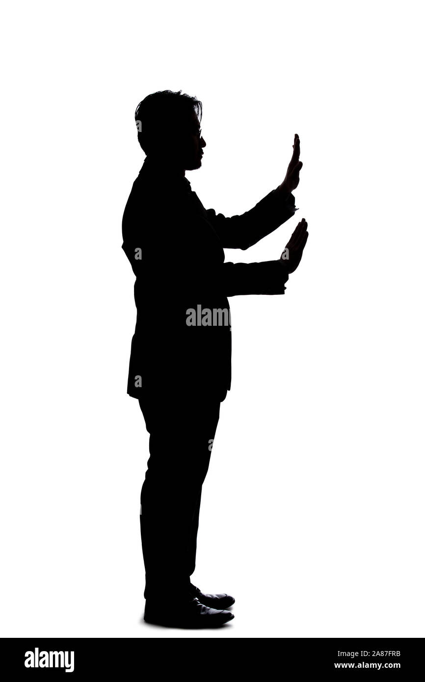 Silhouette of a backlit model posing as a businessman on a white ...