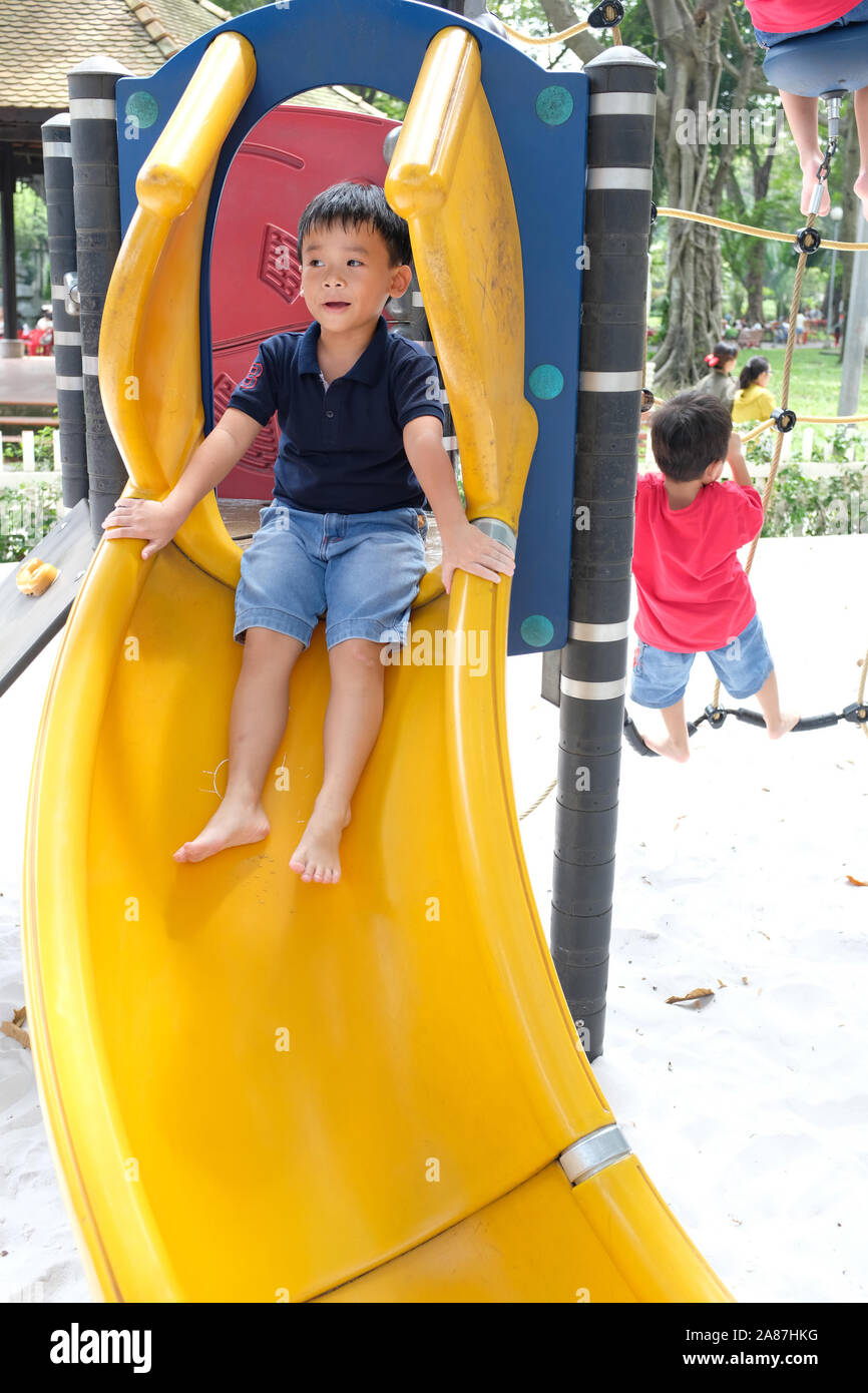 Active boy sliding down in public playground Stock Photo - Alamy