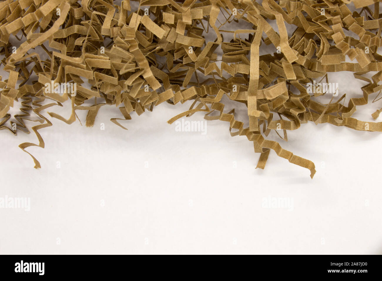 This is a photograph of Brown shredded paper isolated on a White ...