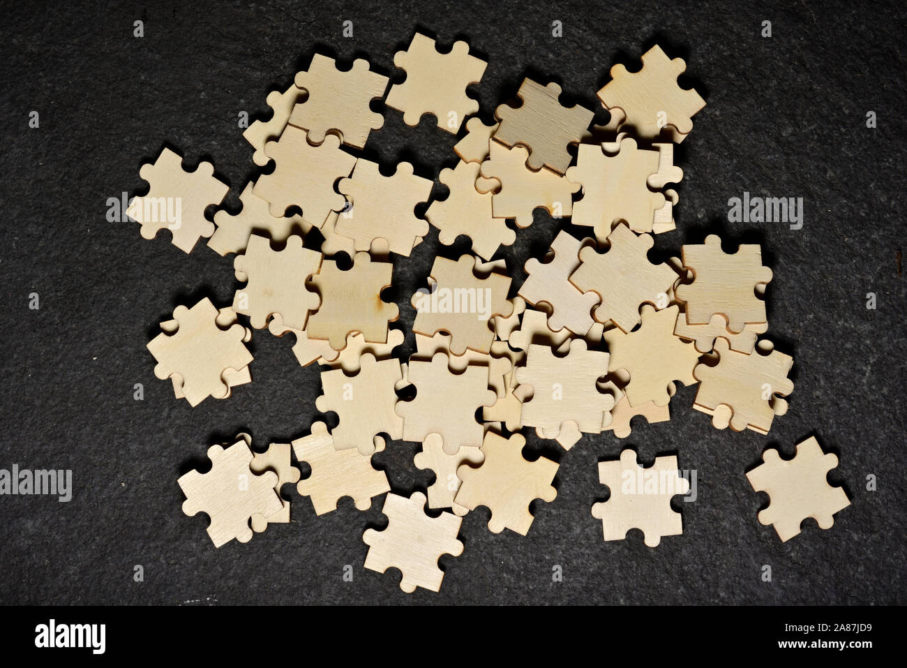 Chaos and confusion: detail of wooden jigsaw puzzle pieces mixed on ...