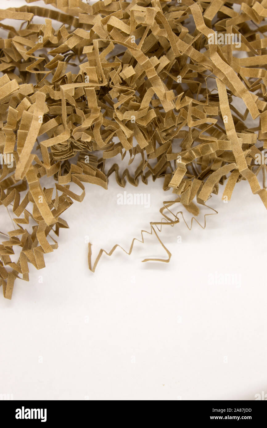 This is a photograph of Brown shredded paper isolated on a White ...