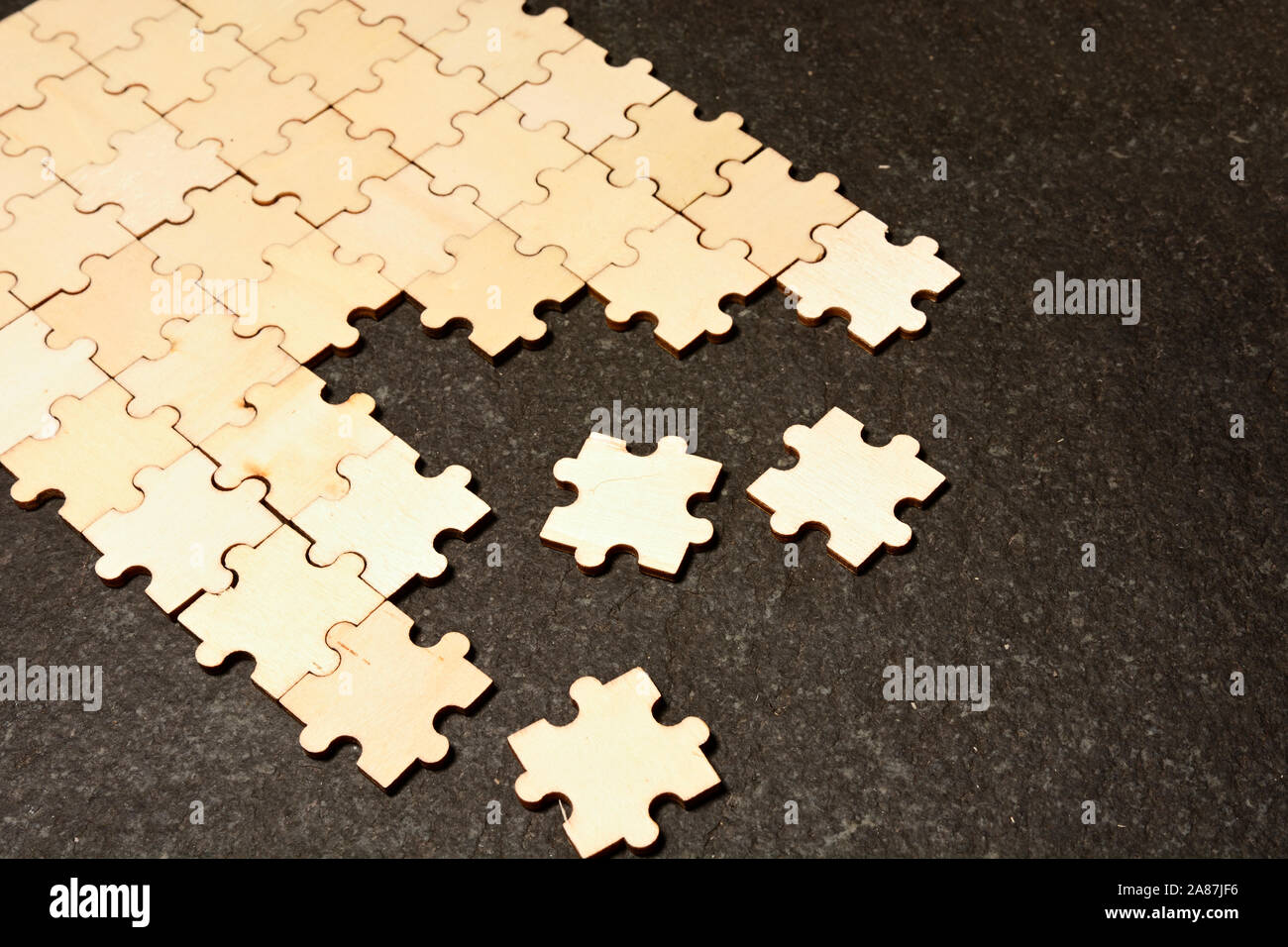 Half ordered puzzle with white jigsaw pieces. One side of the image ...