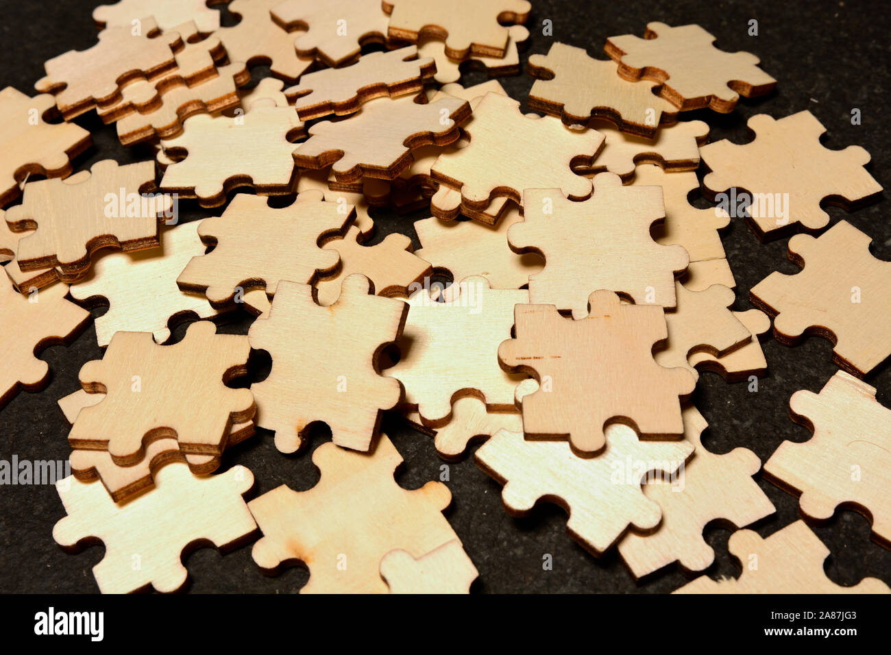 Chaos and confusion: detail of wooden jigsaw puzzle pieces mixed on ...