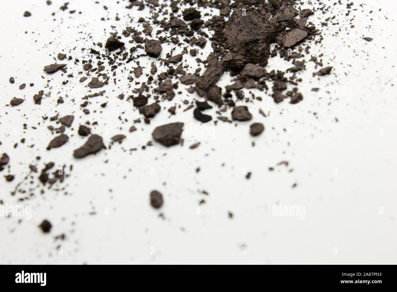 This is a photograph of a dark Brown powder Eye shadow isolated on a ...