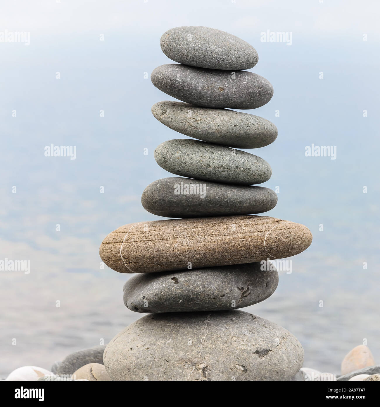 Pyramid of sea stones on pebbles of the sea shore. Seascape. The ...